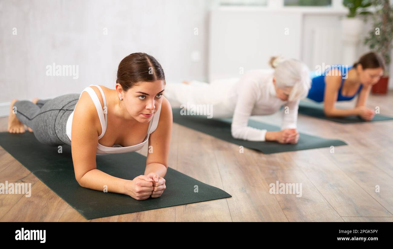 Young mature women pushing-up and being on hands and feet with straight ...