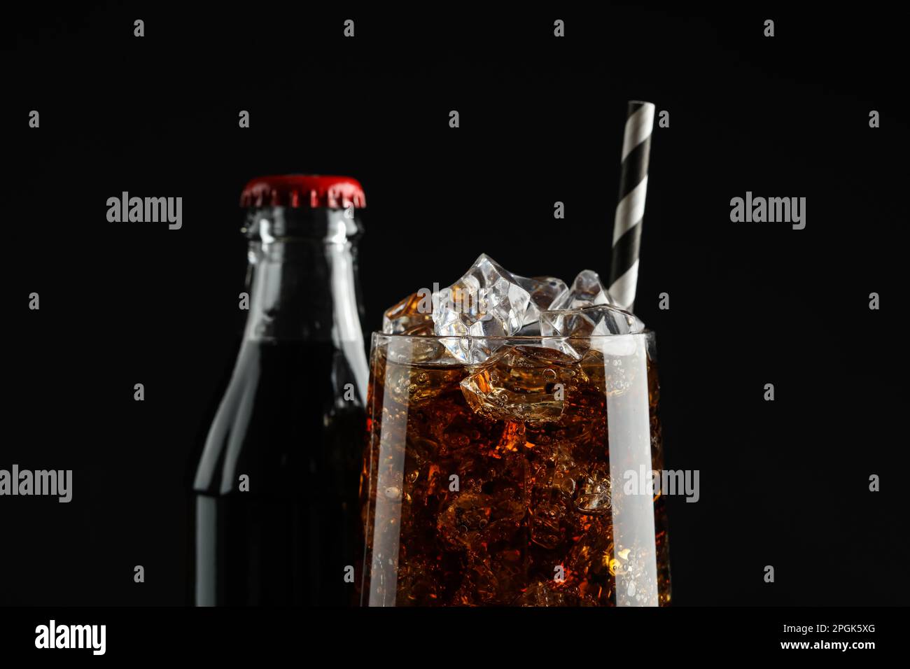 Bottle and glass of refreshing soda water on black background, closeup ...