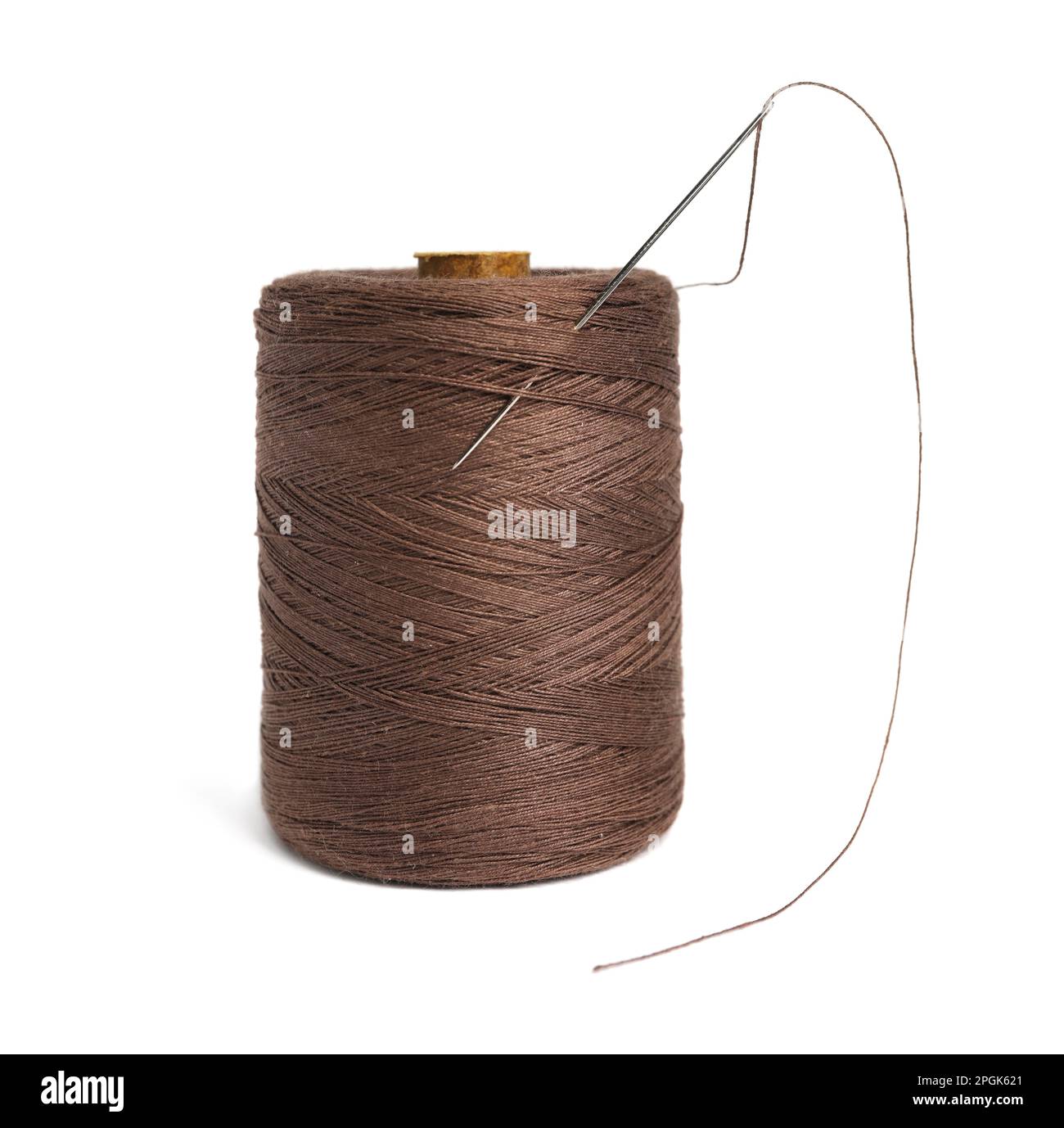 Brown sewing thread with needle on white background Stock Photo - Alamy