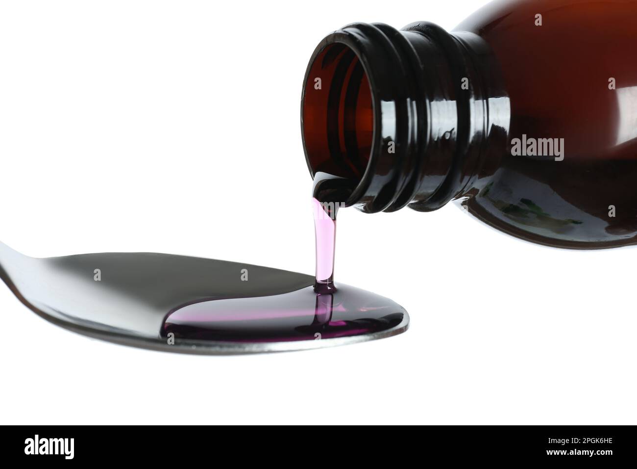 Pouring cough syrup into spoon on white background Stock Photo - Alamy