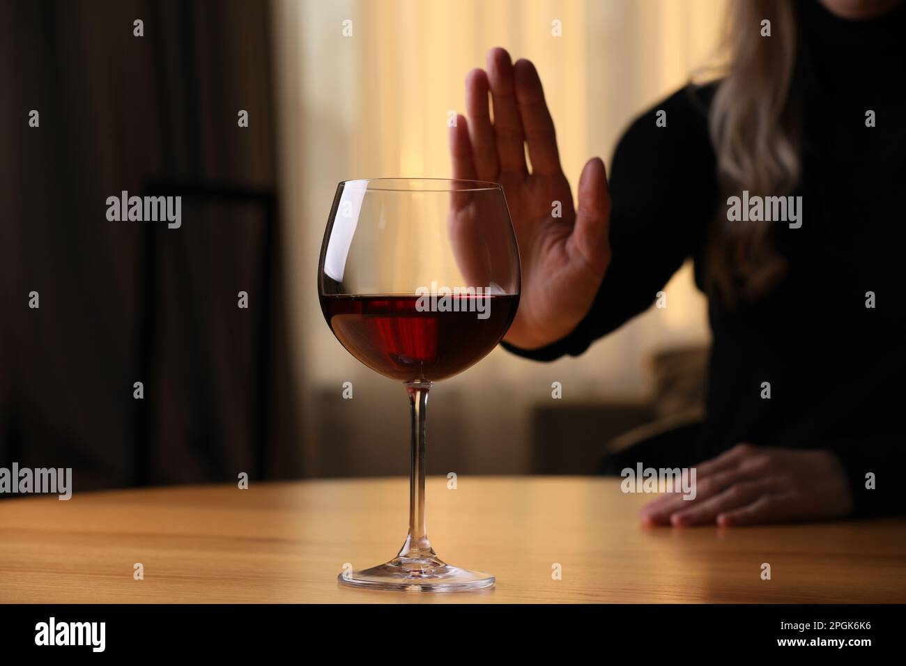Woman refusing to drink red wine at home, closeup. Alcohol addiction ...