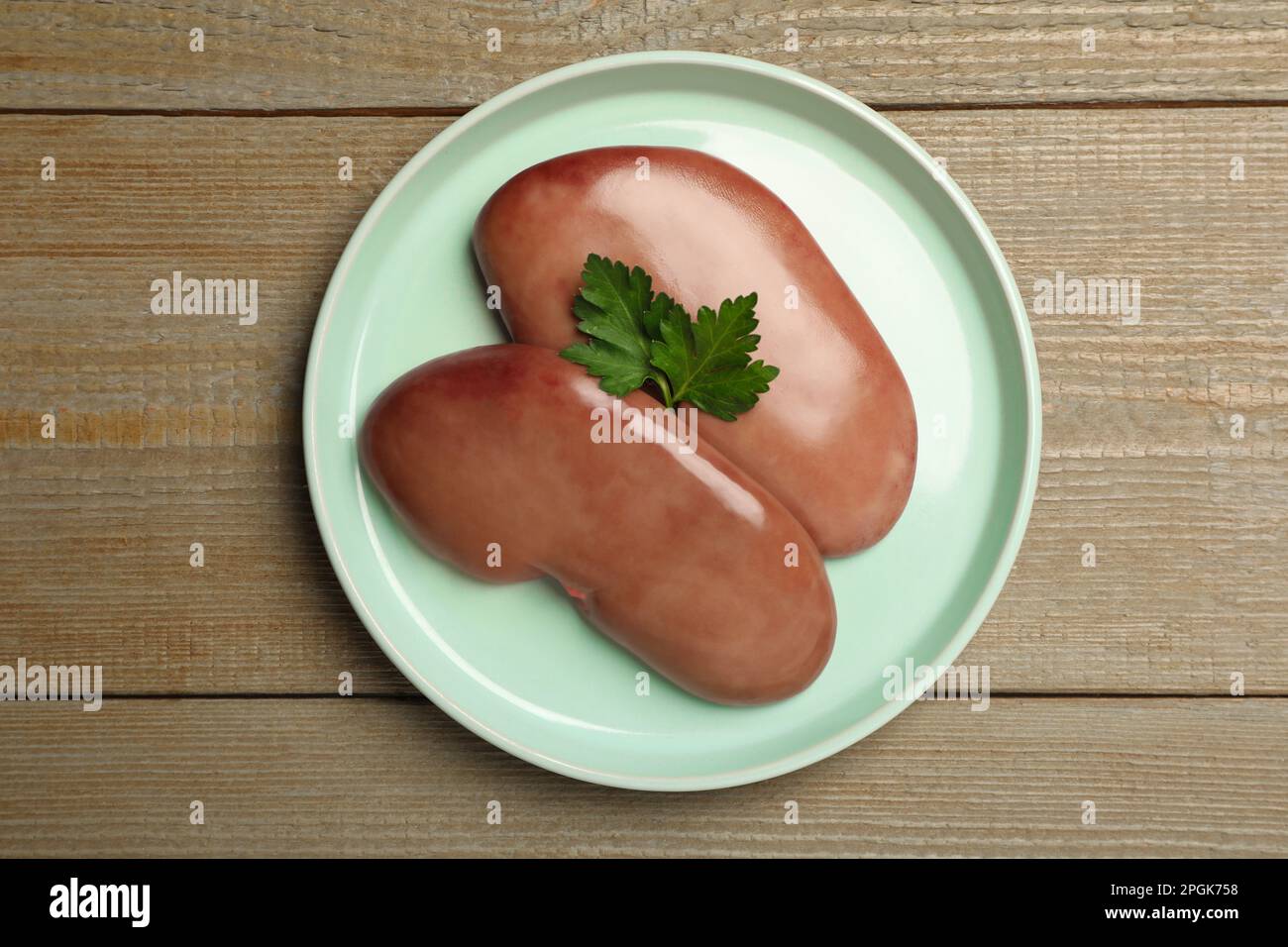 Fresh raw pork kidneys with parsley on wooden table, top view Stock ...