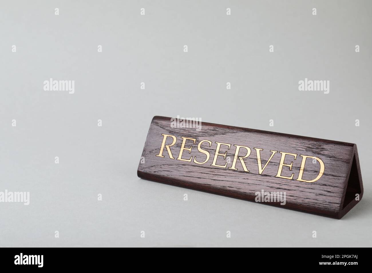 Elegant wooden sign RESERVED on light grey background, space for text ...