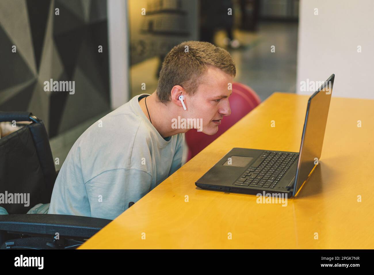 Handsome young invalid disabled man talking on mobile phone in kittchen ...
