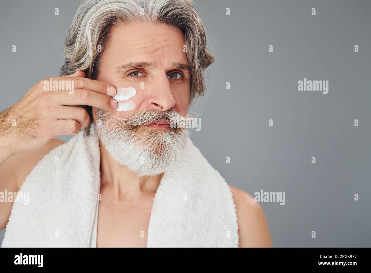 Taking care of face and skin clearness. Stylish modern senior man with ...