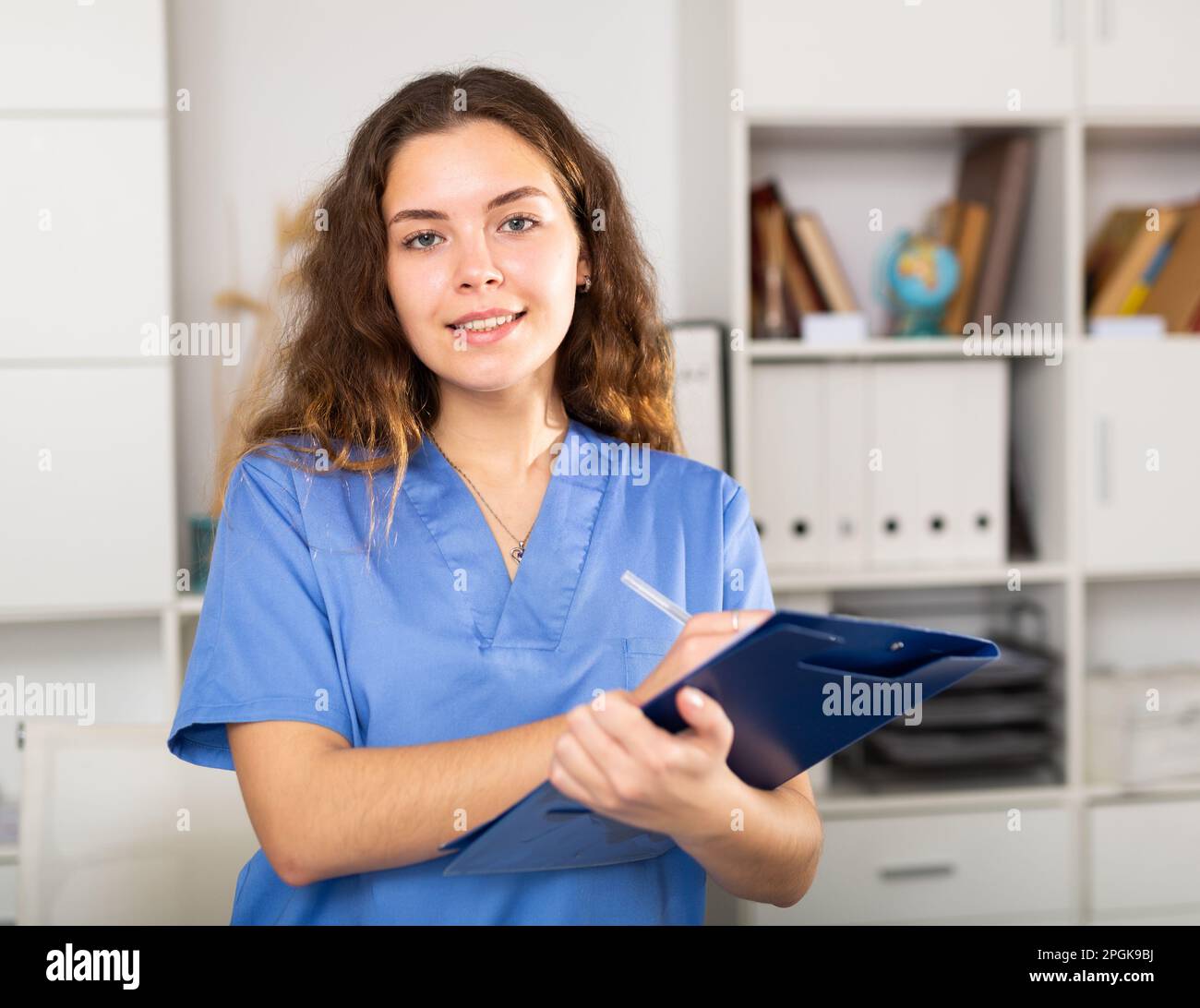 Positive doctor female in blue shirt standing in medical center Stock ...