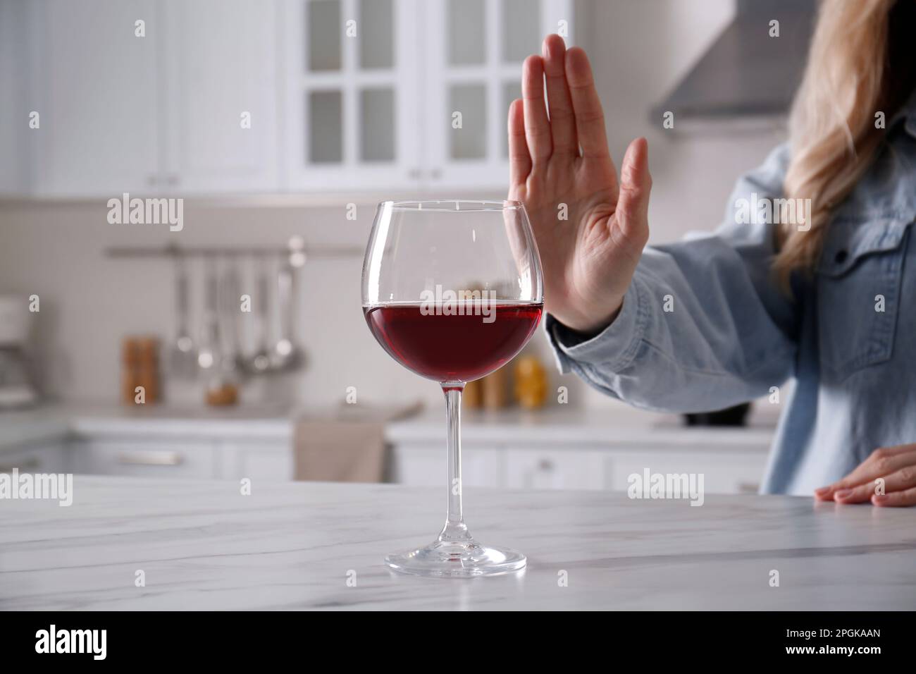 Woman refusing to drink red wine at home, closeup. Alcohol addiction ...