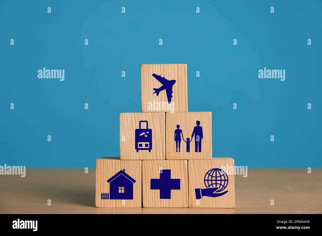 Cubes with different icons on wooden table against light blue ...