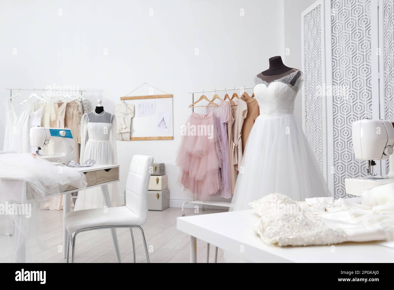 Dressmaking workshop interior with wedding dresses, female clothes and ...