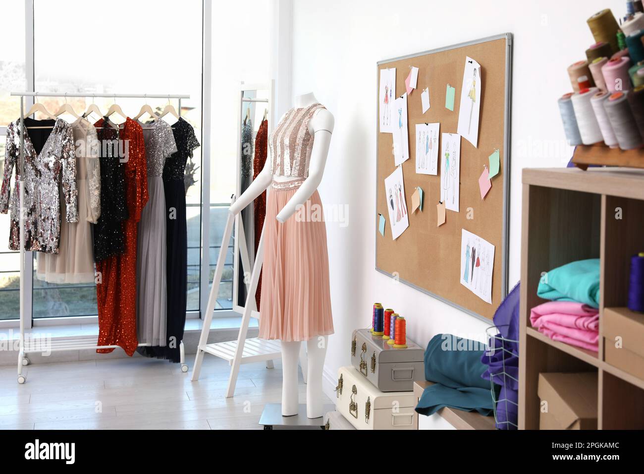 Dressmaking workshop interior with stylish female clothes and equipment ...