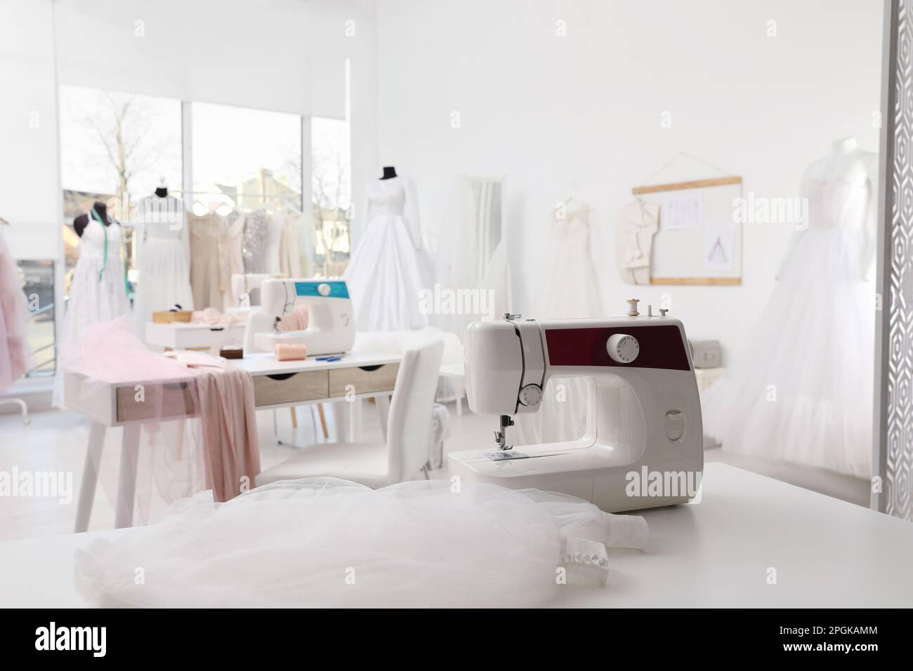 Sewing machine and fabric on table in dressmaking workshop Stock Photo ...
