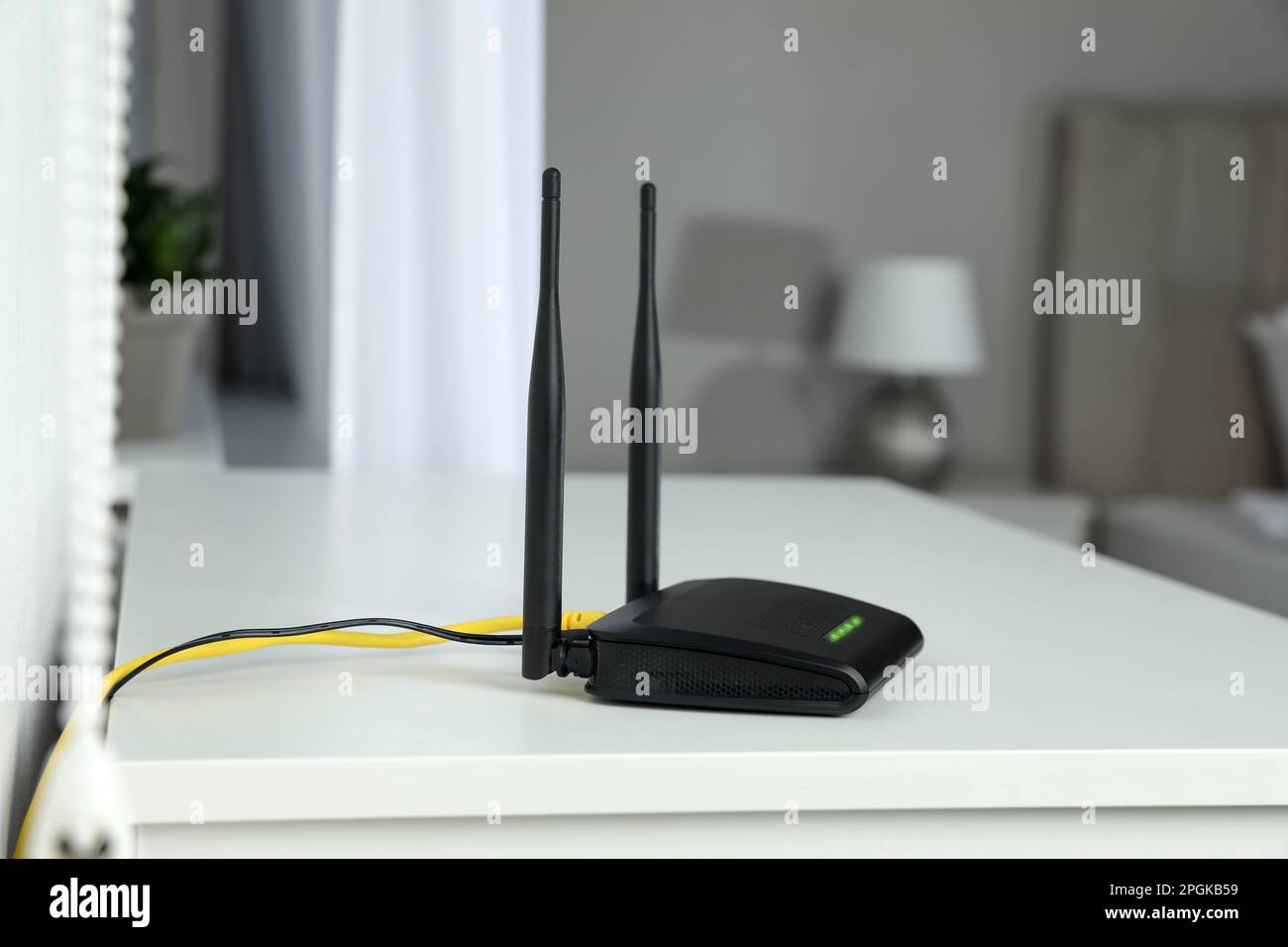 Modern Wi-Fi router on white table in room Stock Photo - Alamy
