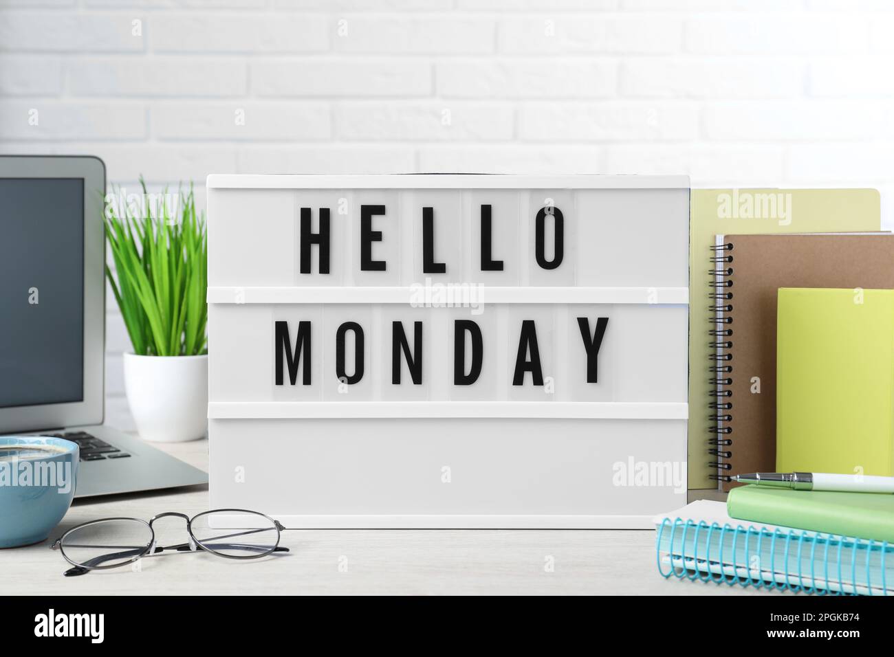 Light box with message Hello Monday, office stationery and laptop on ...