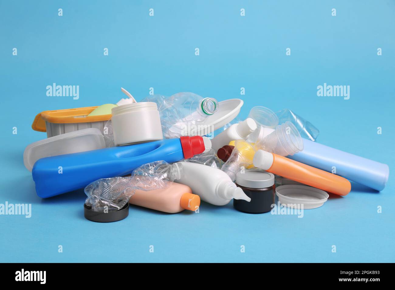 Pile of plastic garbage on light blue background Stock Photo - Alamy