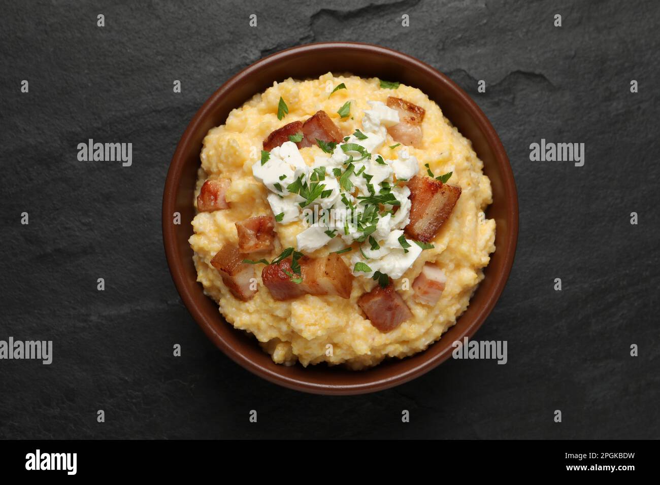 Delicious traditional Ukrainian banosh in bowl on black table, top view ...