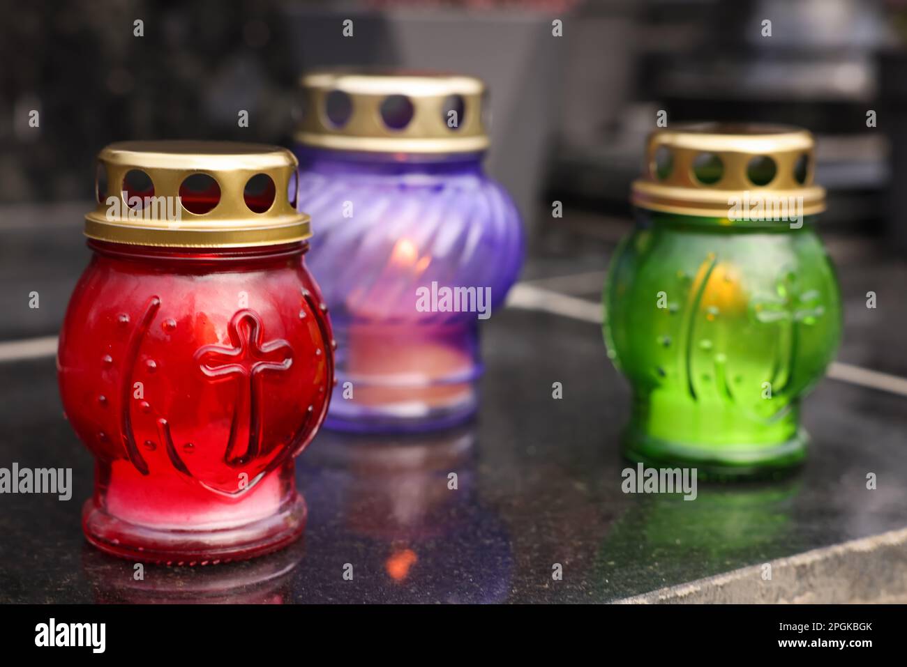 Different grave lanterns on granite surface at cemetery Stock Photo - Alamy