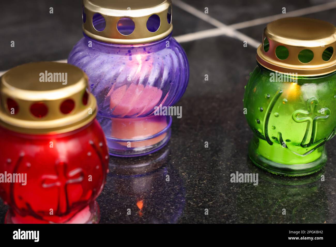 Different grave lanterns on granite surface at cemetery closeup Stock ...