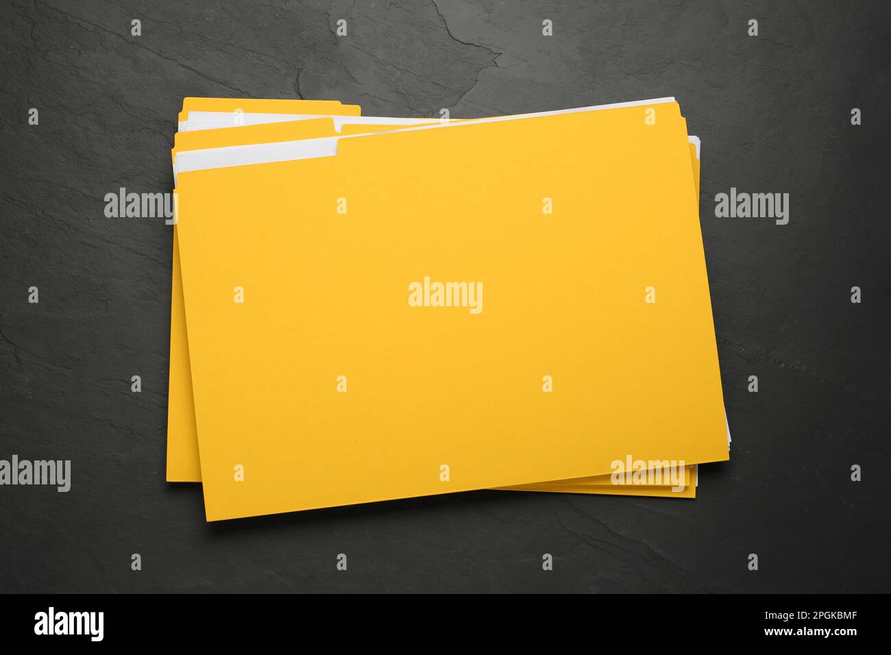 Yellow files with documents on black slate table, top view Stock Photo ...