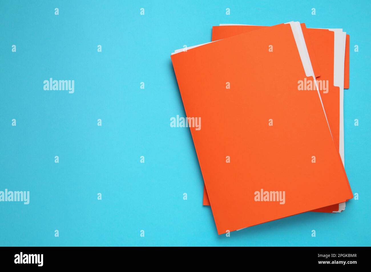 Orange files with documents on turquoise background, top view. Space ...