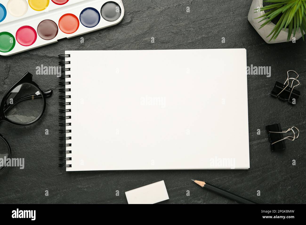 Flat lay composition with blank sketchbook on black slate table. Space ...