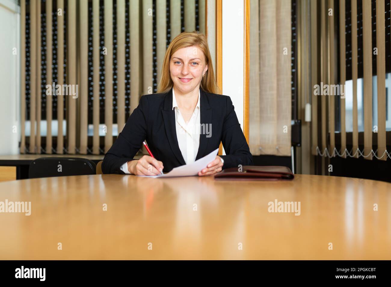 Business woman in office interior filling up documents Stock Photo - Alamy