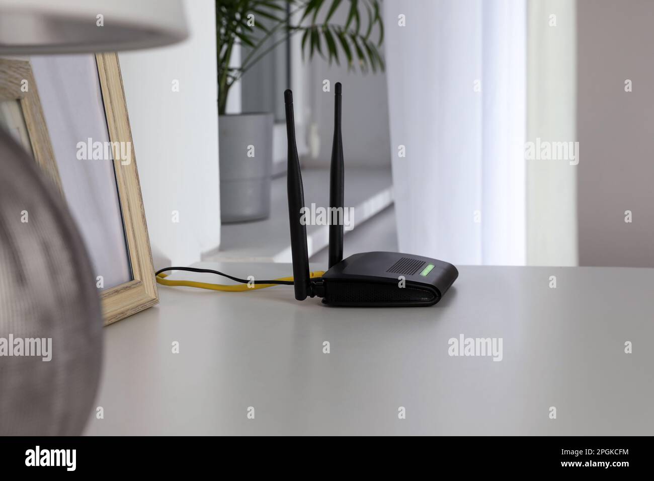 Modern Wi-Fi router on white table in room Stock Photo - Alamy