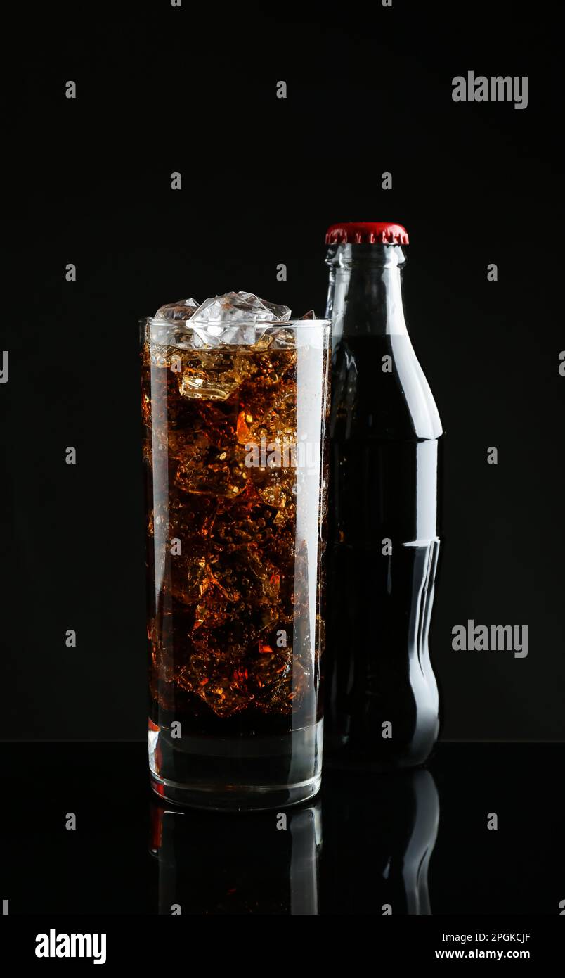 Bottle and glass of refreshing soda water on black background Stock ...