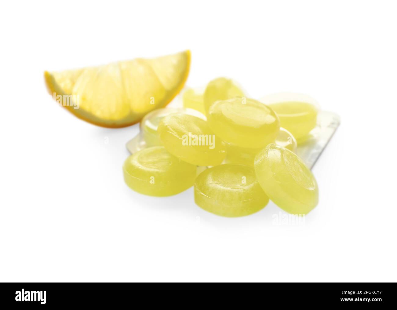 Many yellow cough drops and slice of lemon on white background Stock ...