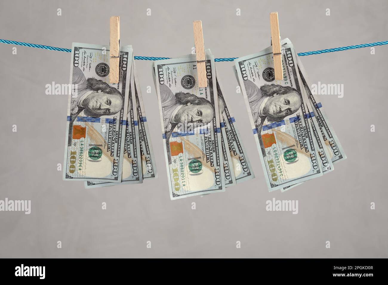 Dollar banknotes hanging on rope against light grey background Stock ...