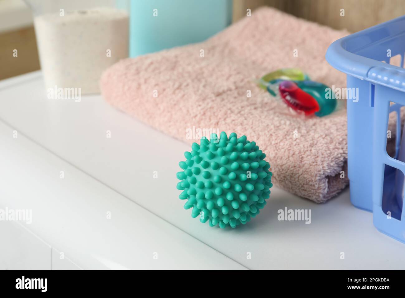 Turquoise dryer ball, detergents and towel on washing machine Stock ...