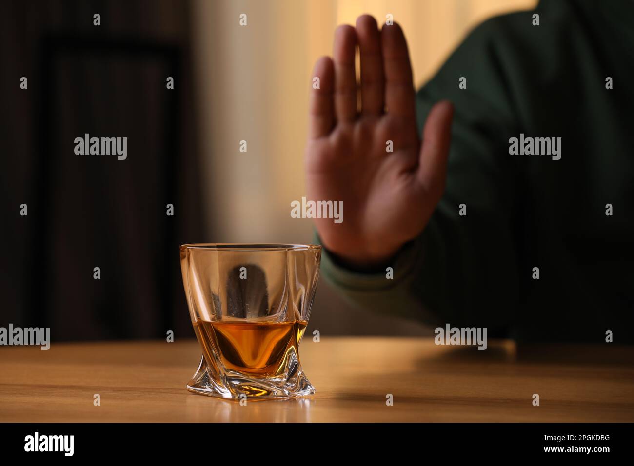 Man refusing to drink whiskey indoors, closeup. Alcohol addiction ...