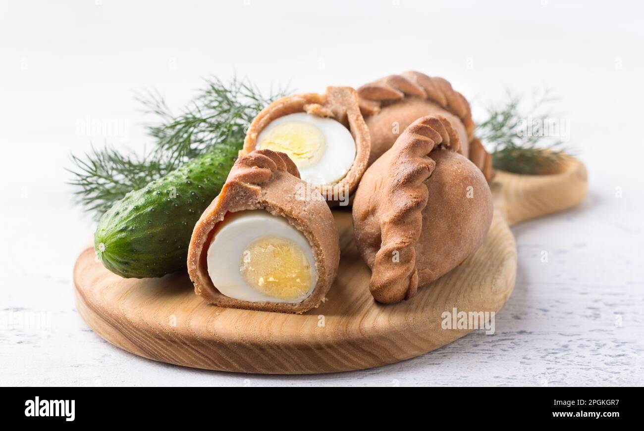 Russian traditional rye pies with egg, kokurki, on a light gray ...