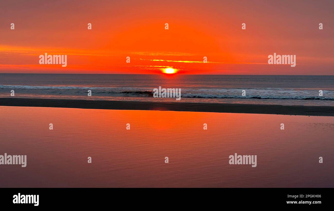 A stunning view of a bright vibrant sunset sky over a sea Stock Photo ...