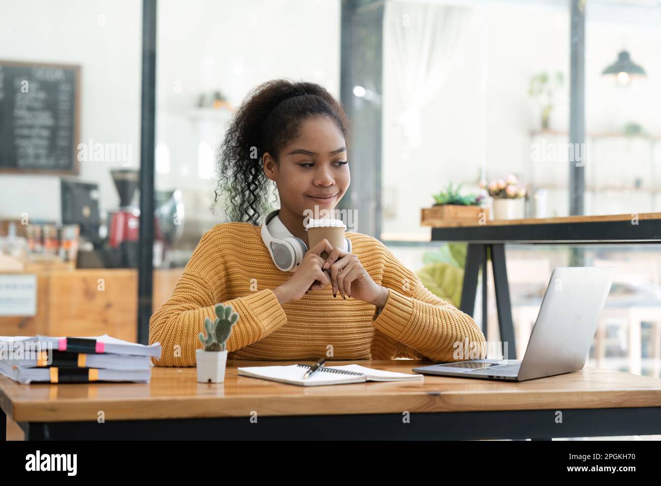 Beautiful American women student studying online takes notes on her ...