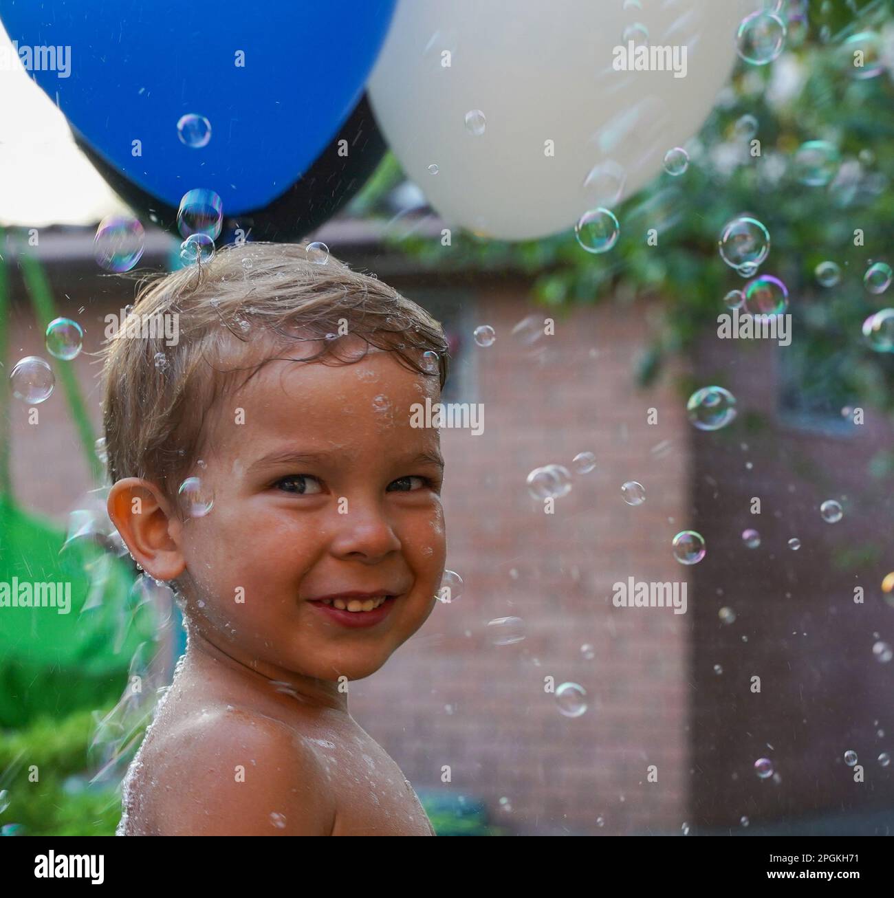 Happy birthday. A 3-4 year old child is having fun in a park with balls ...