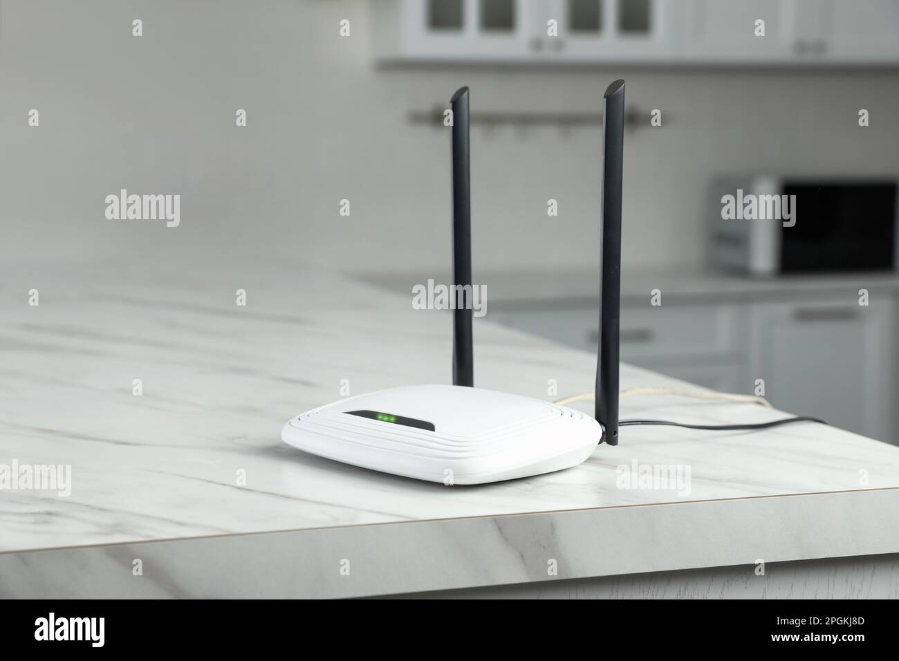Modern Wi-Fi router on white marble table in kitchen Stock Photo - Alamy