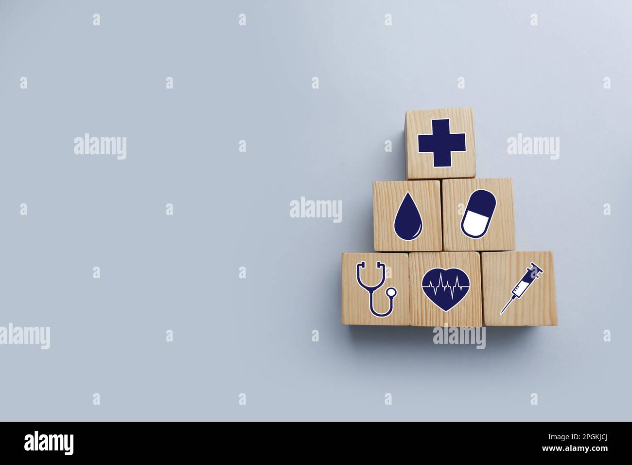 Wooden cubes with different icons on light grey background, flat lay ...