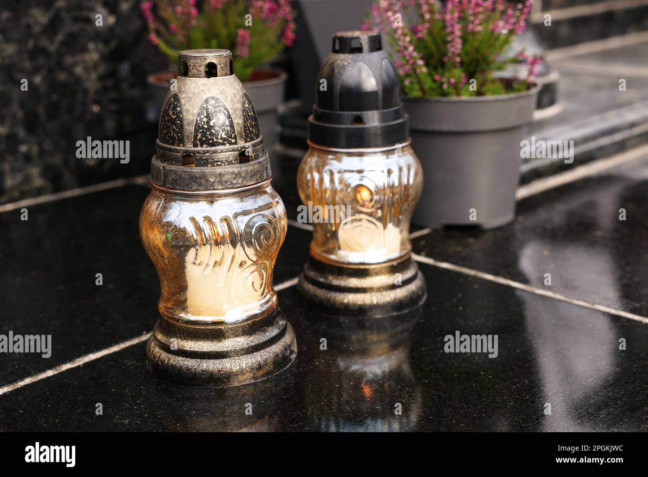 Grave lanterns on black tiled surface at cemetery Stock Photo - Alamy