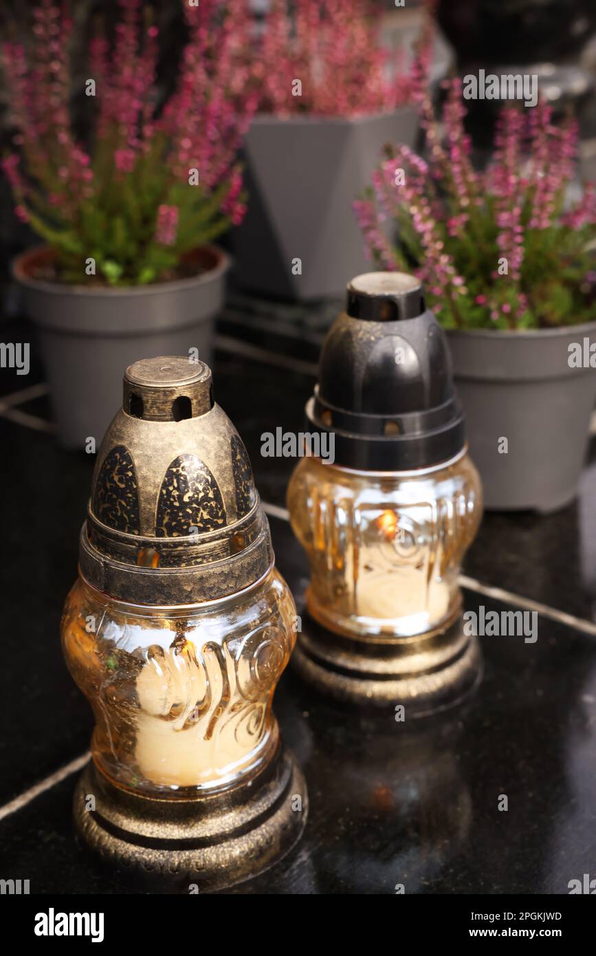 Grave lanterns on black tiled surface at cemetery Stock Photo - Alamy
