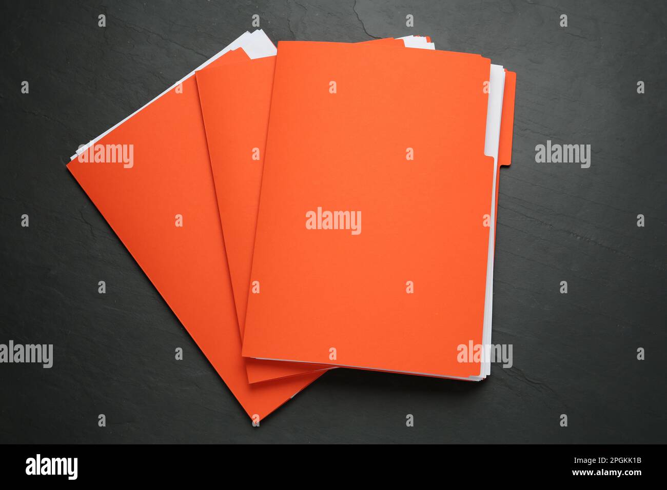 Orange files with documents on black slate table, top view Stock Photo ...