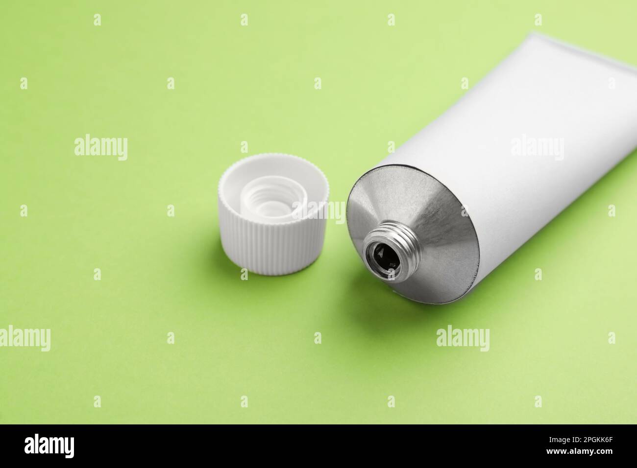 Open white tube of ointment on light green background, closeup Stock ...