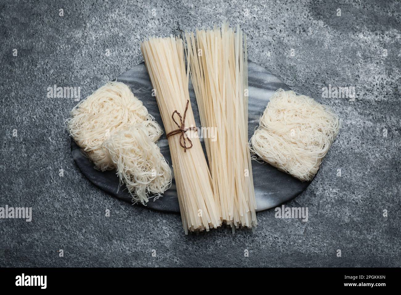 Different uncooked rice noodles on grey table, top view Stock Photo - Alamy