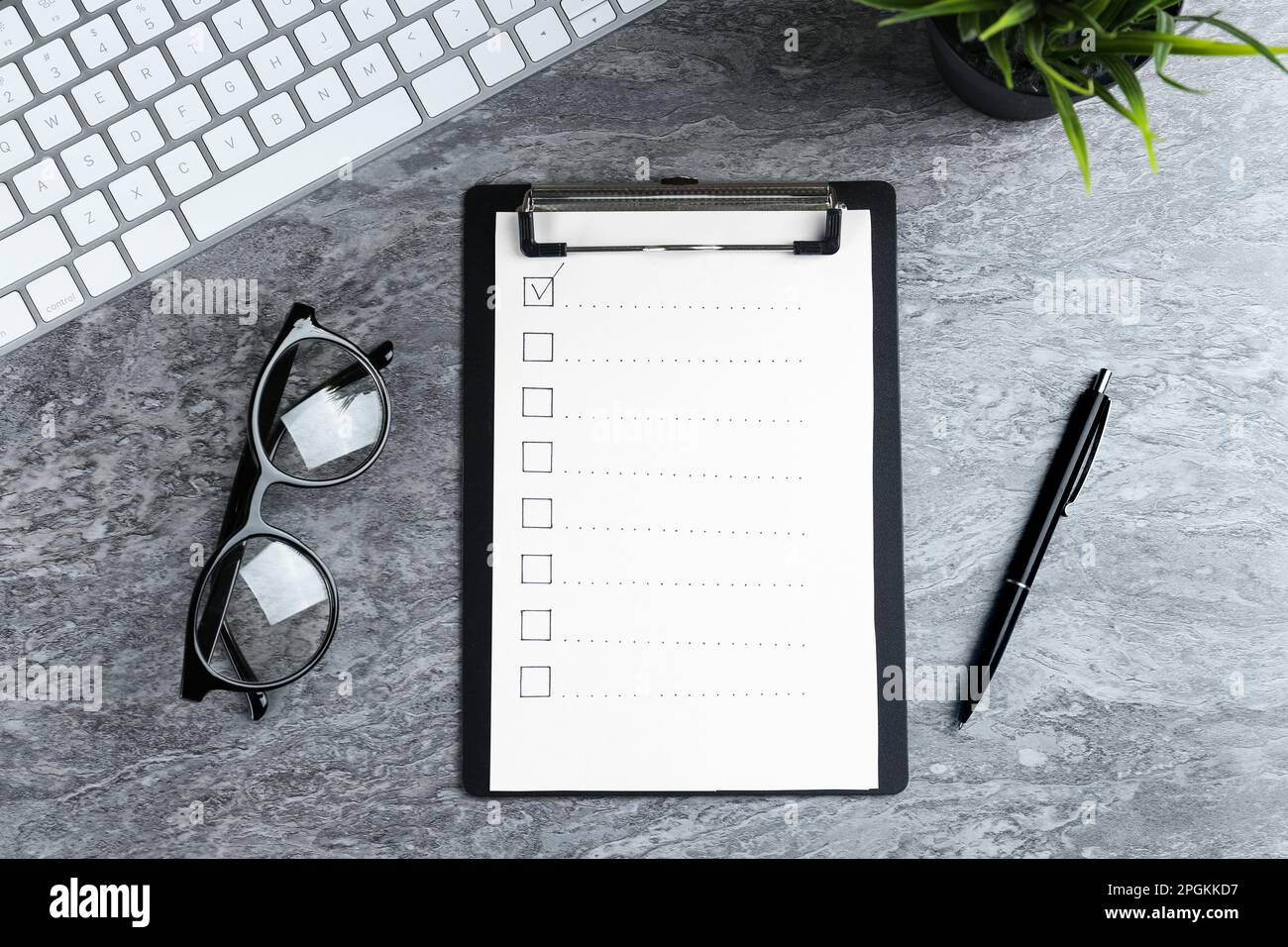 Clipboard with checkboxes, computer keyboard, eyeglasses and pen on ...