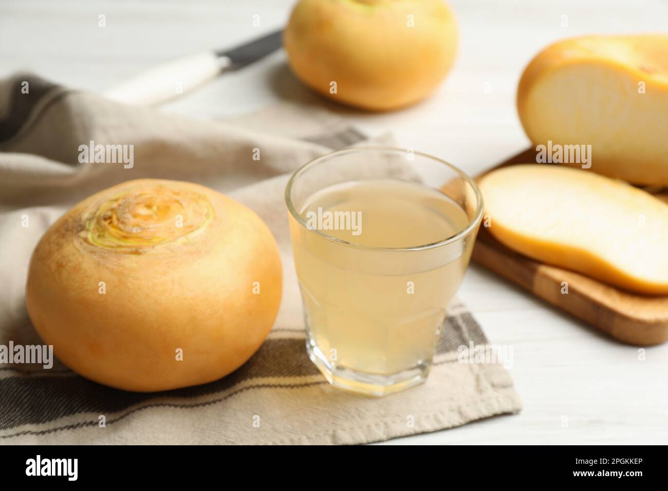 Glass of fresh natural turnip juice, cut and whole roots on white table ...