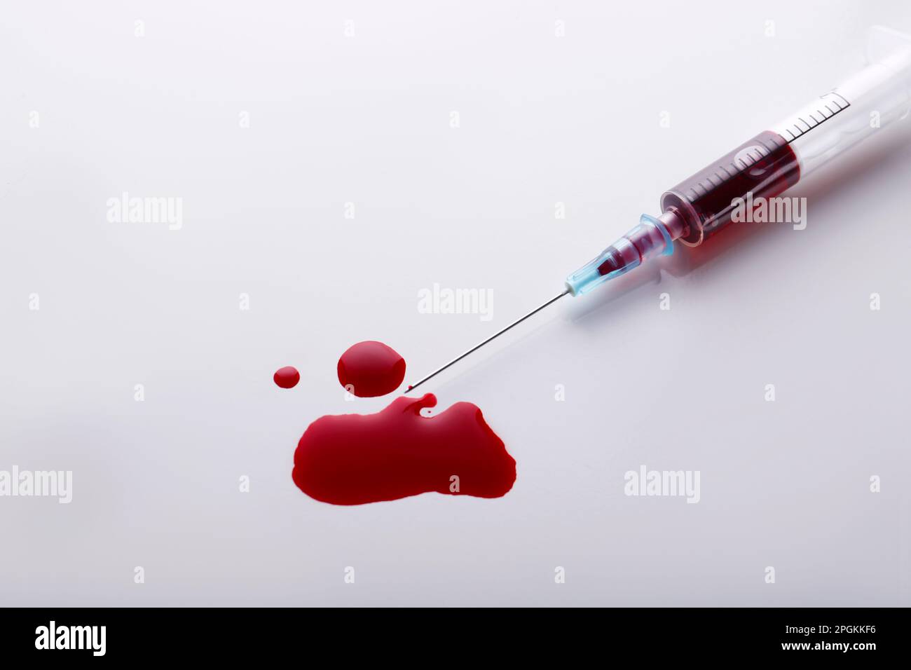 Plastic syringe with blood on white background Stock Photo - Alamy