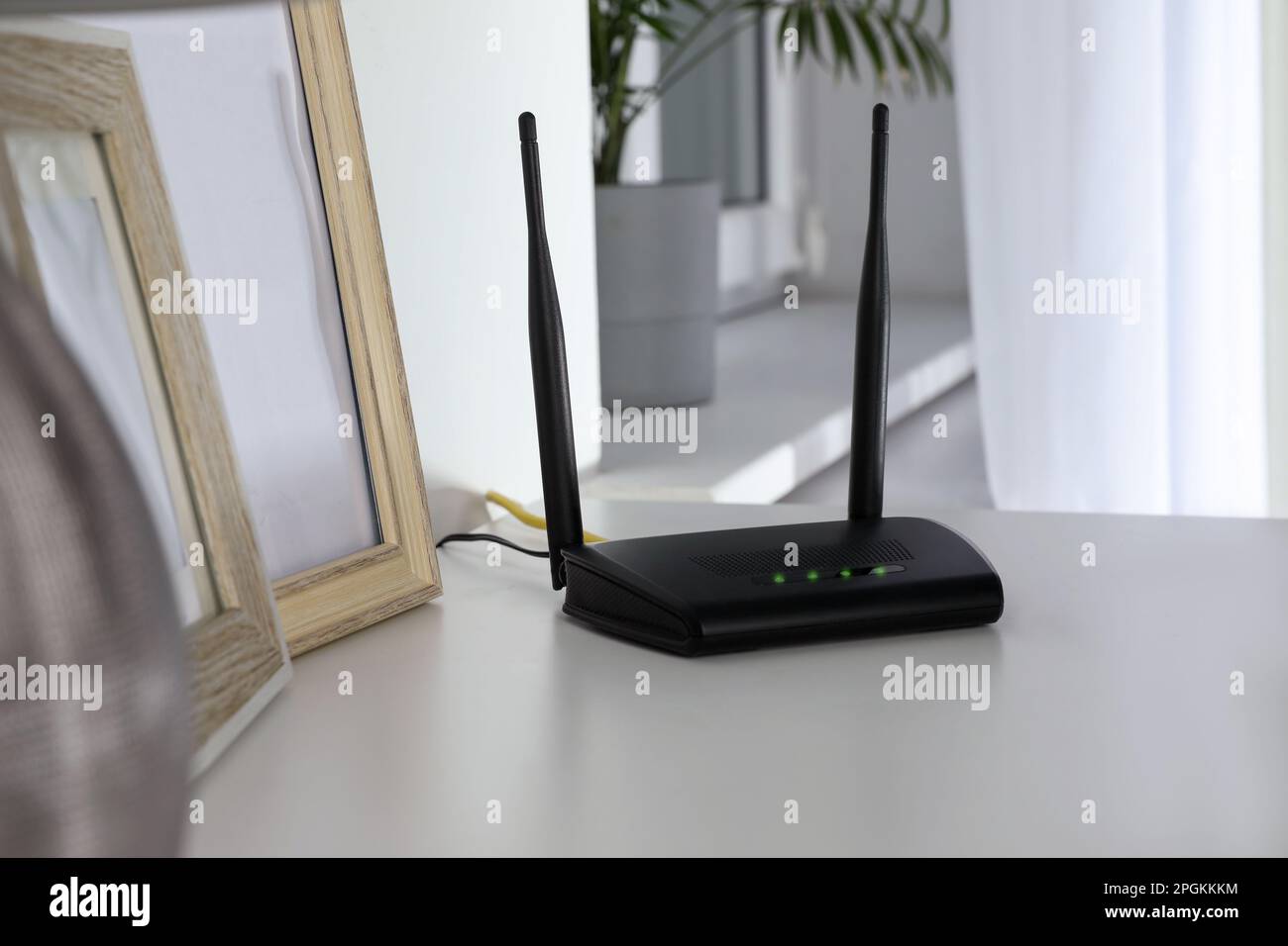 Modern Wi-Fi router on white table in room Stock Photo - Alamy