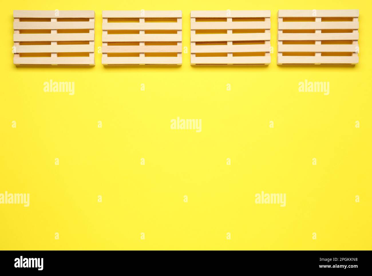 Wooden pallets on yellow background, flat lay. Space or text Stock ...