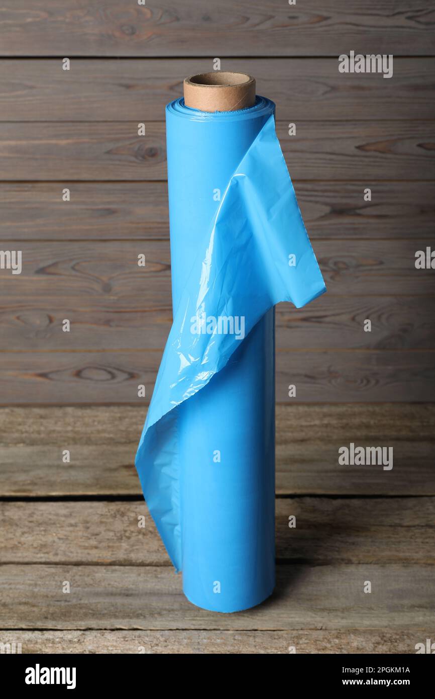 Roll of plastic stretch wrap film on wooden table Stock Photo - Alamy