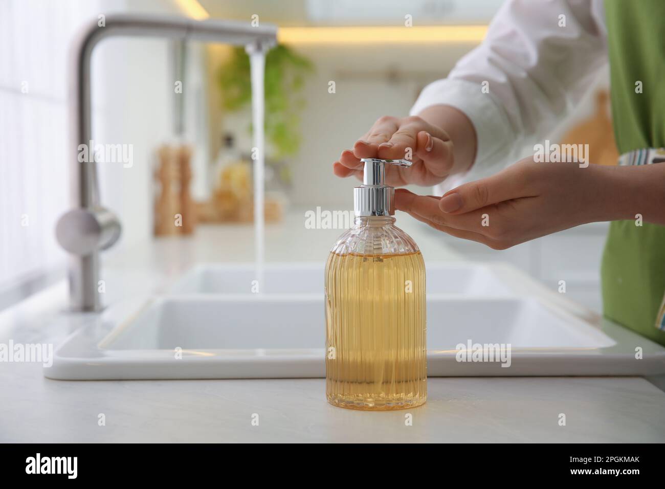 Woman washing hands with liquid soap in kitchen, closeup Stock Photo ...