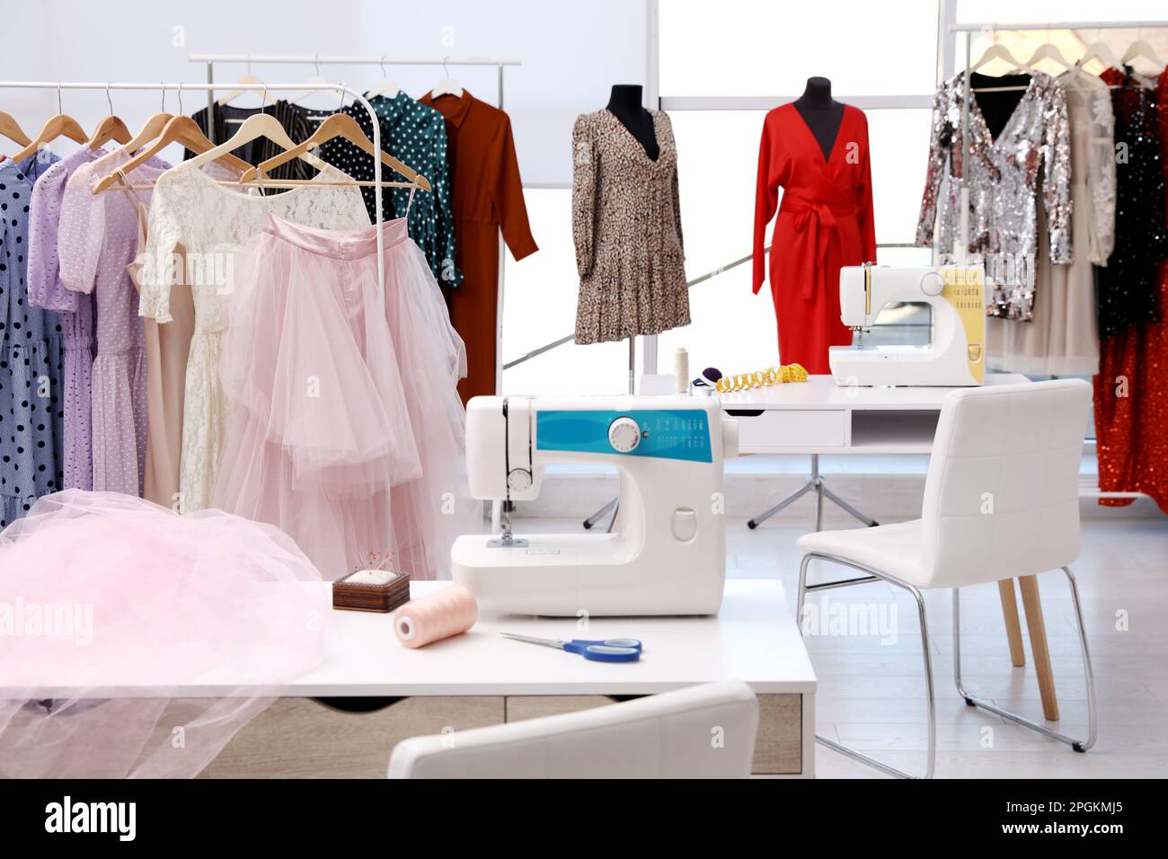 Dressmaking workshop interior with stylish female clothes and equipment ...